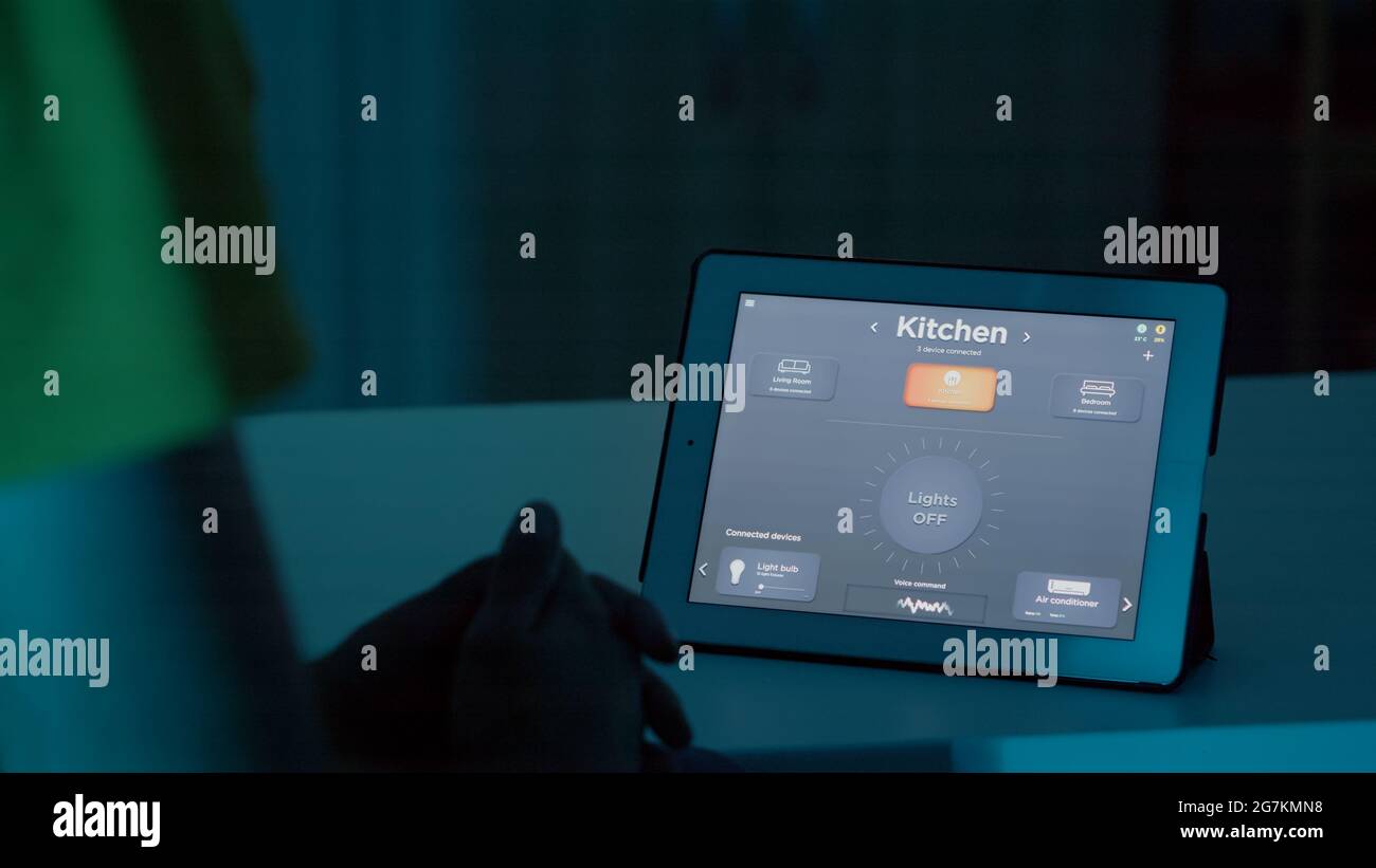 Man sitting at desk in smart home automation system talking to voice ...