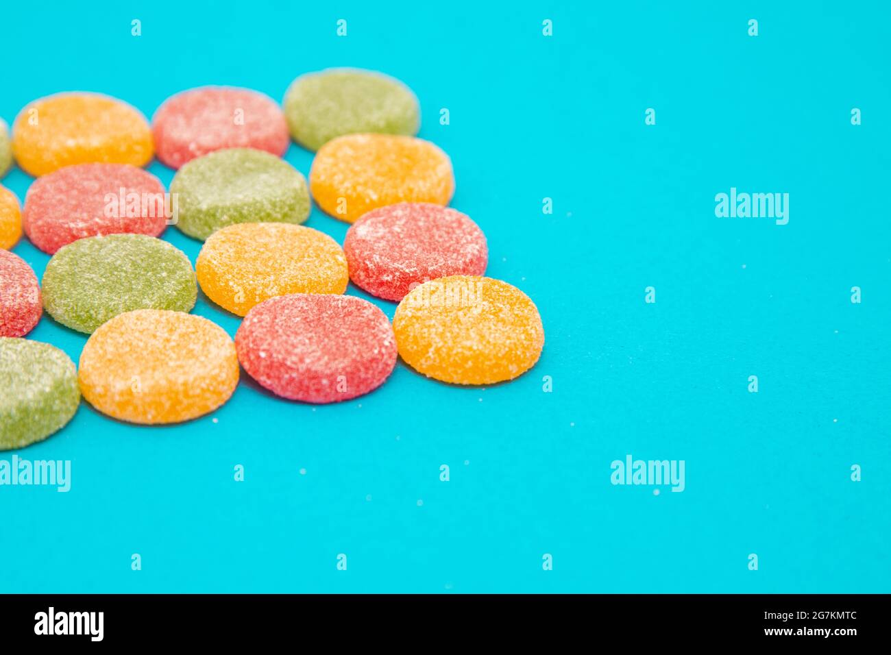 Colored round gummy candies isolated on blue background with copy space ...