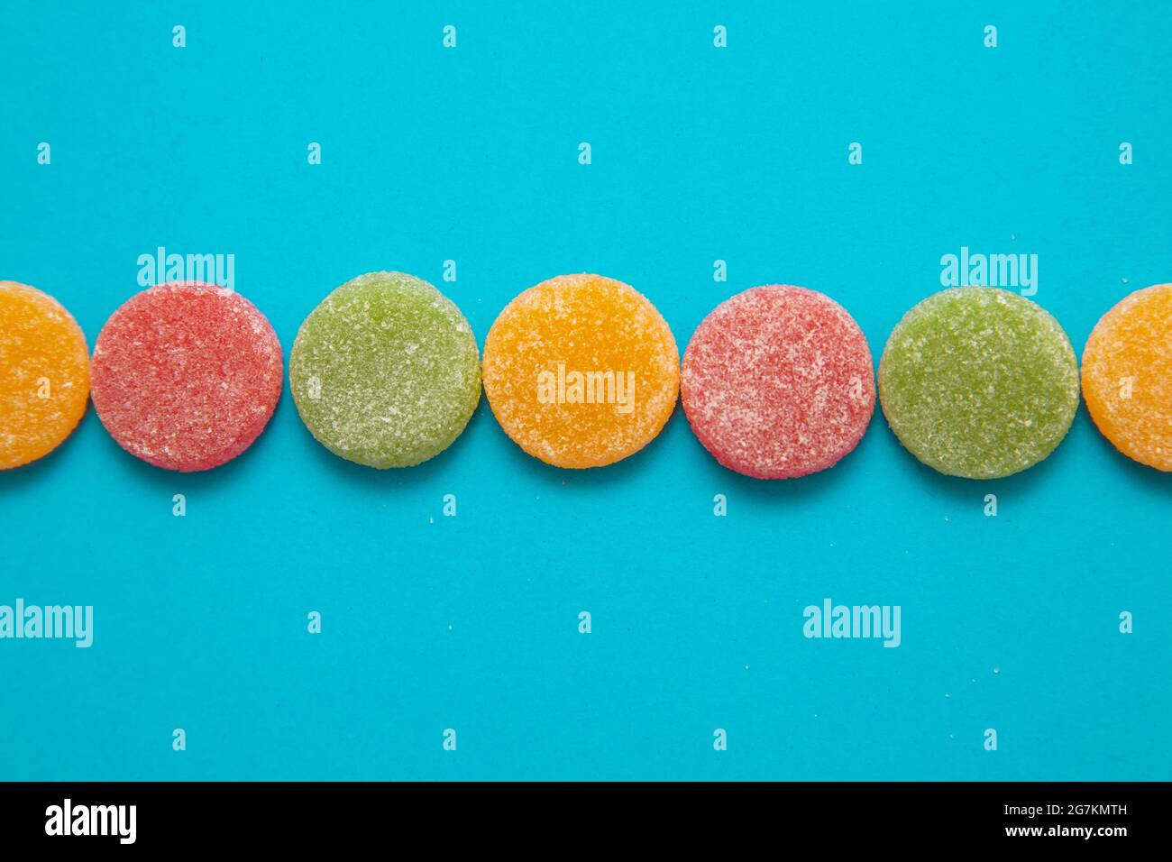 Colored round gummy candies isolated on blue background with copy space ...