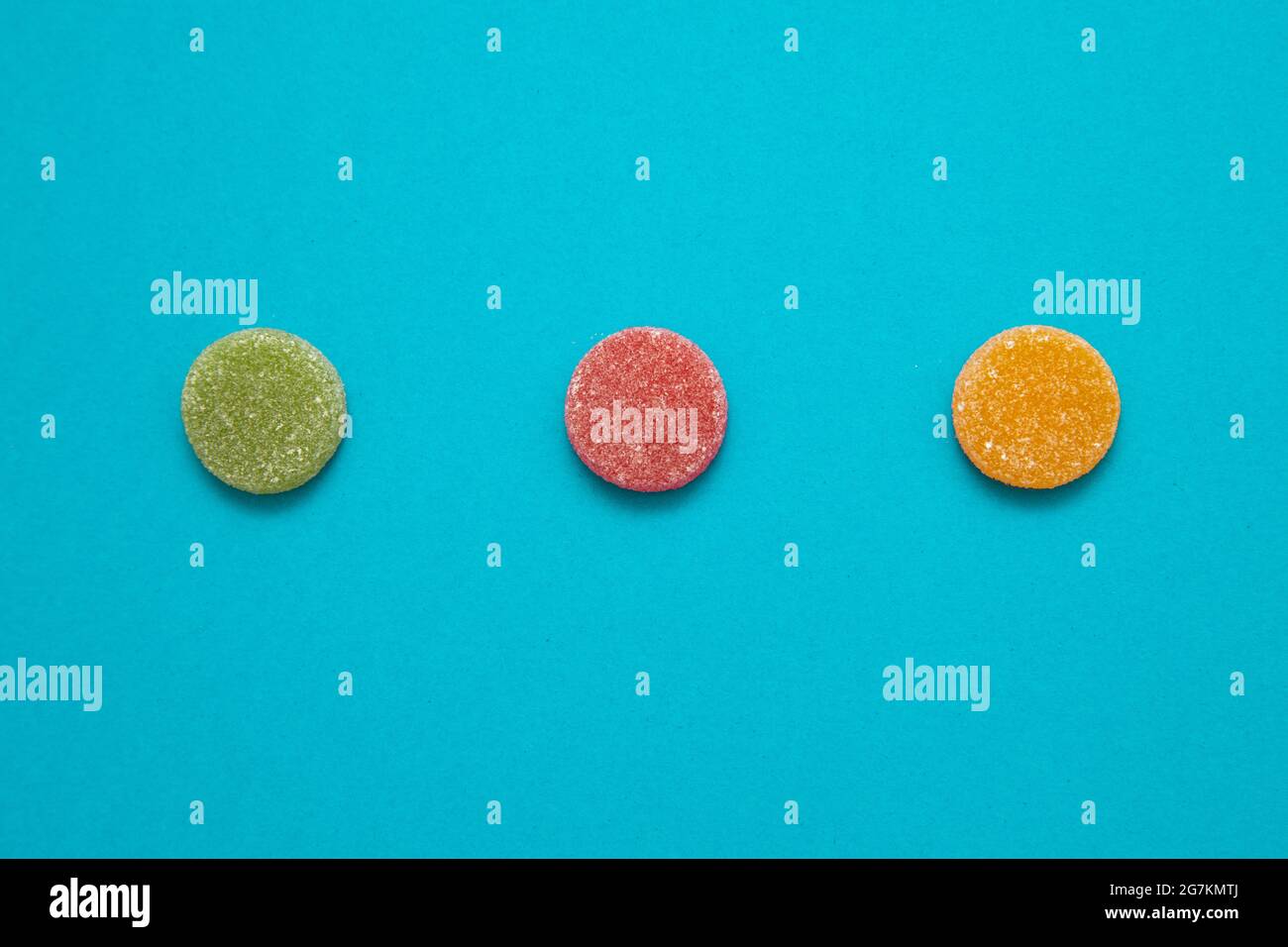 Colored round gummy candies isolated on blue background with copy space ...