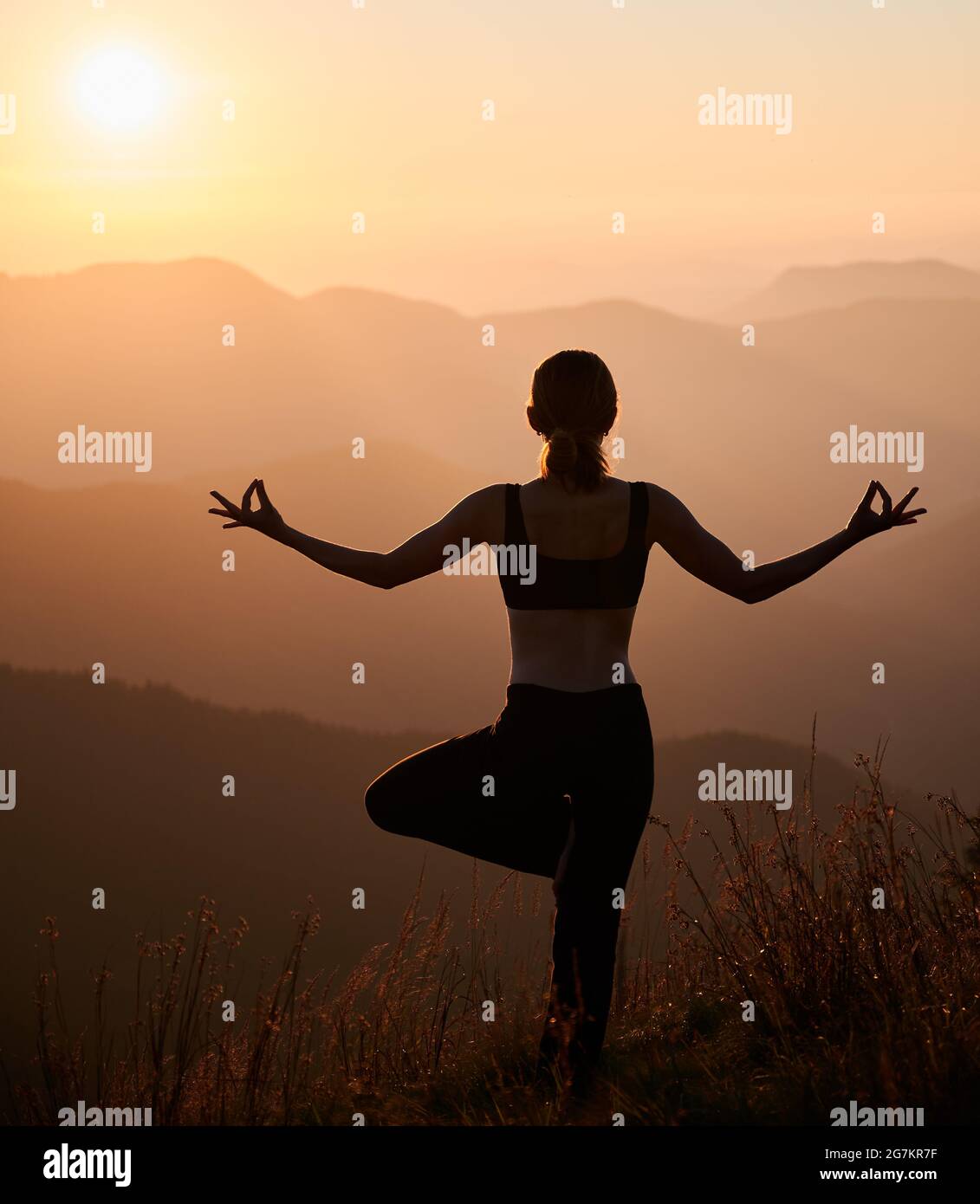 Back view of young slender woman doing exercise yoga on one leg on ...