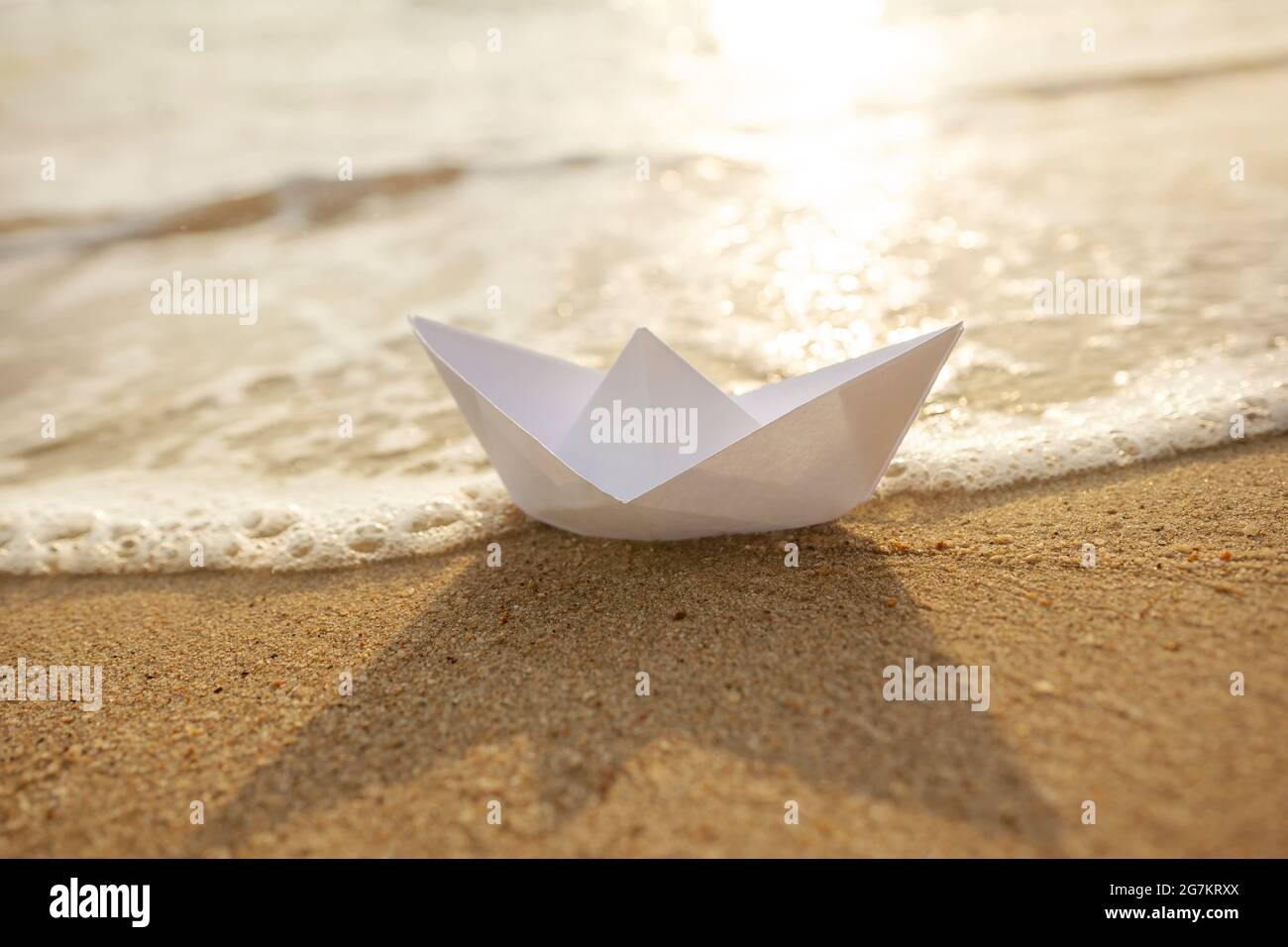 A paper boat on a beautiful beach And soft ocean waves Stock Photo - Alamy