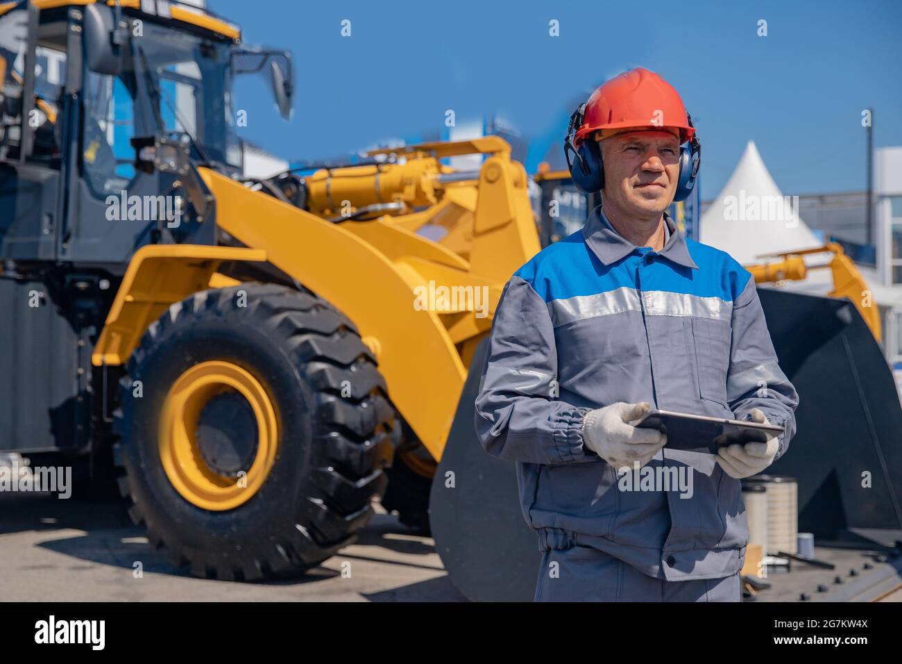 Smart construction site, foreman in helmet controls equipment using ...