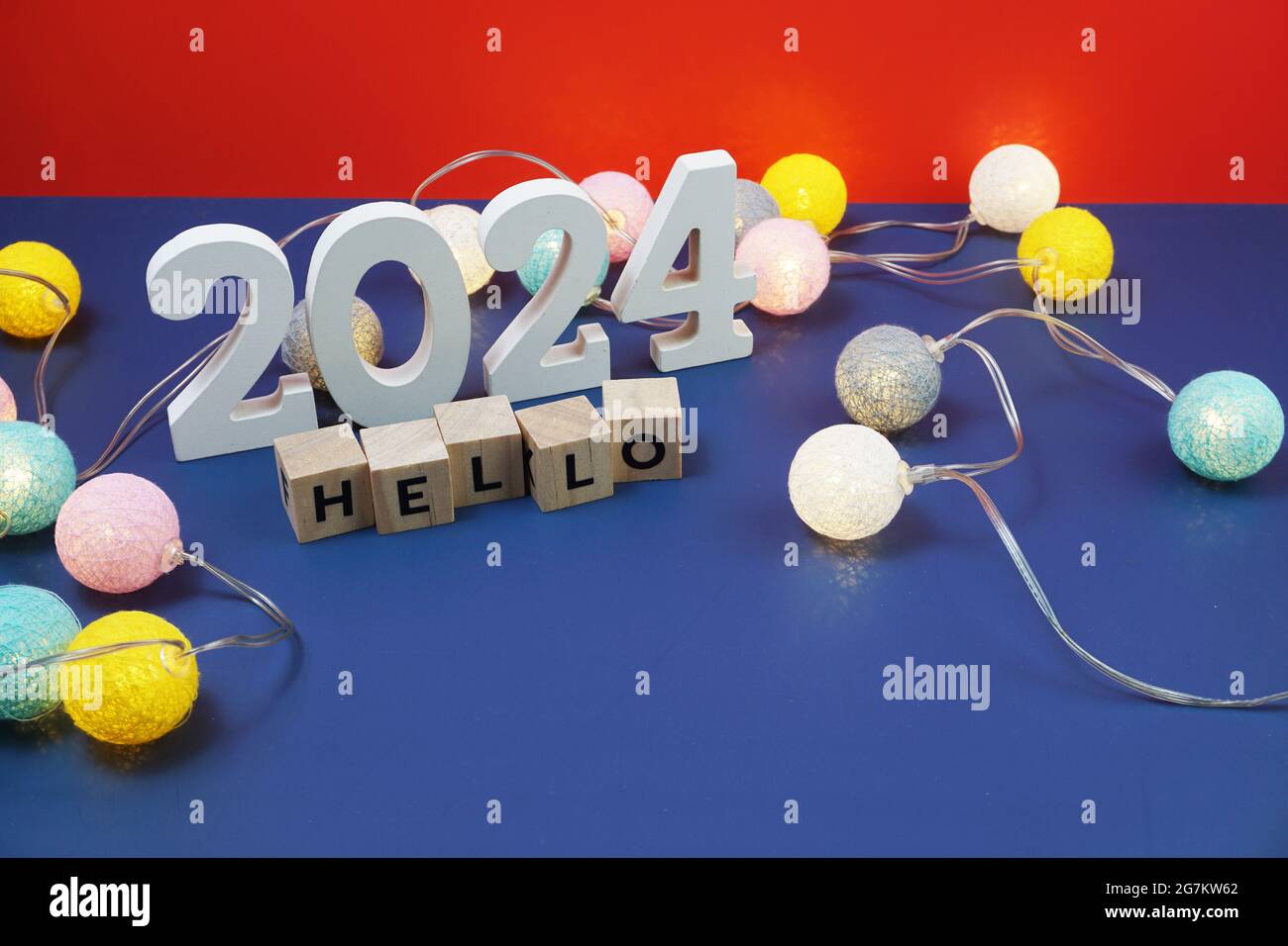 Hello 2024 alphabet letter and alarm clock decorate with LED cotton ball on blue and red ...