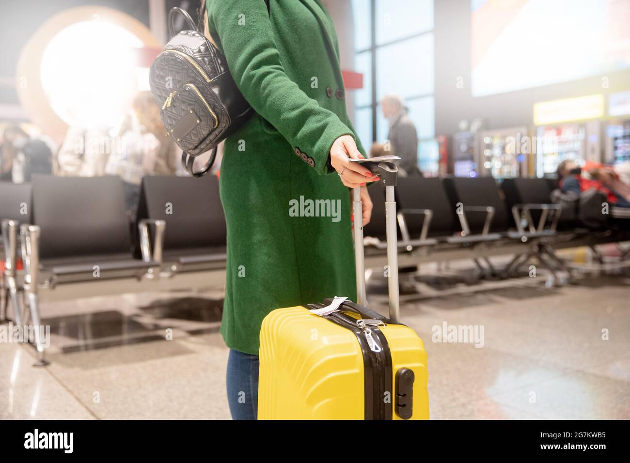 Faceless girl in green coat holds passport with ticket and yellow ...