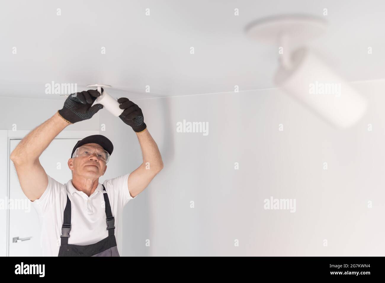 Electrician man worker install lamp lighting and spot loft style on ...