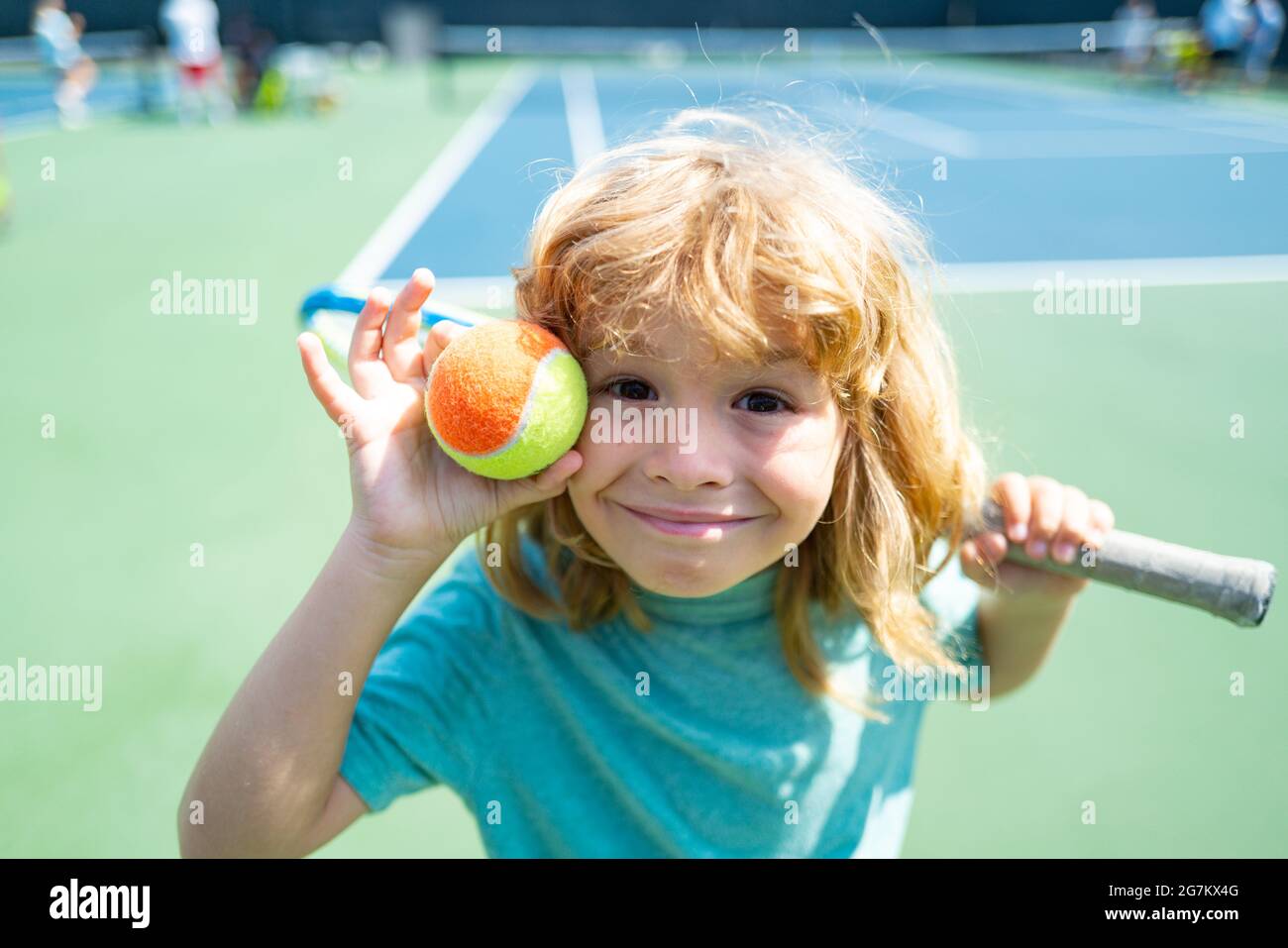 Cute kid boy with tennis racket on court at the tennis competition ...