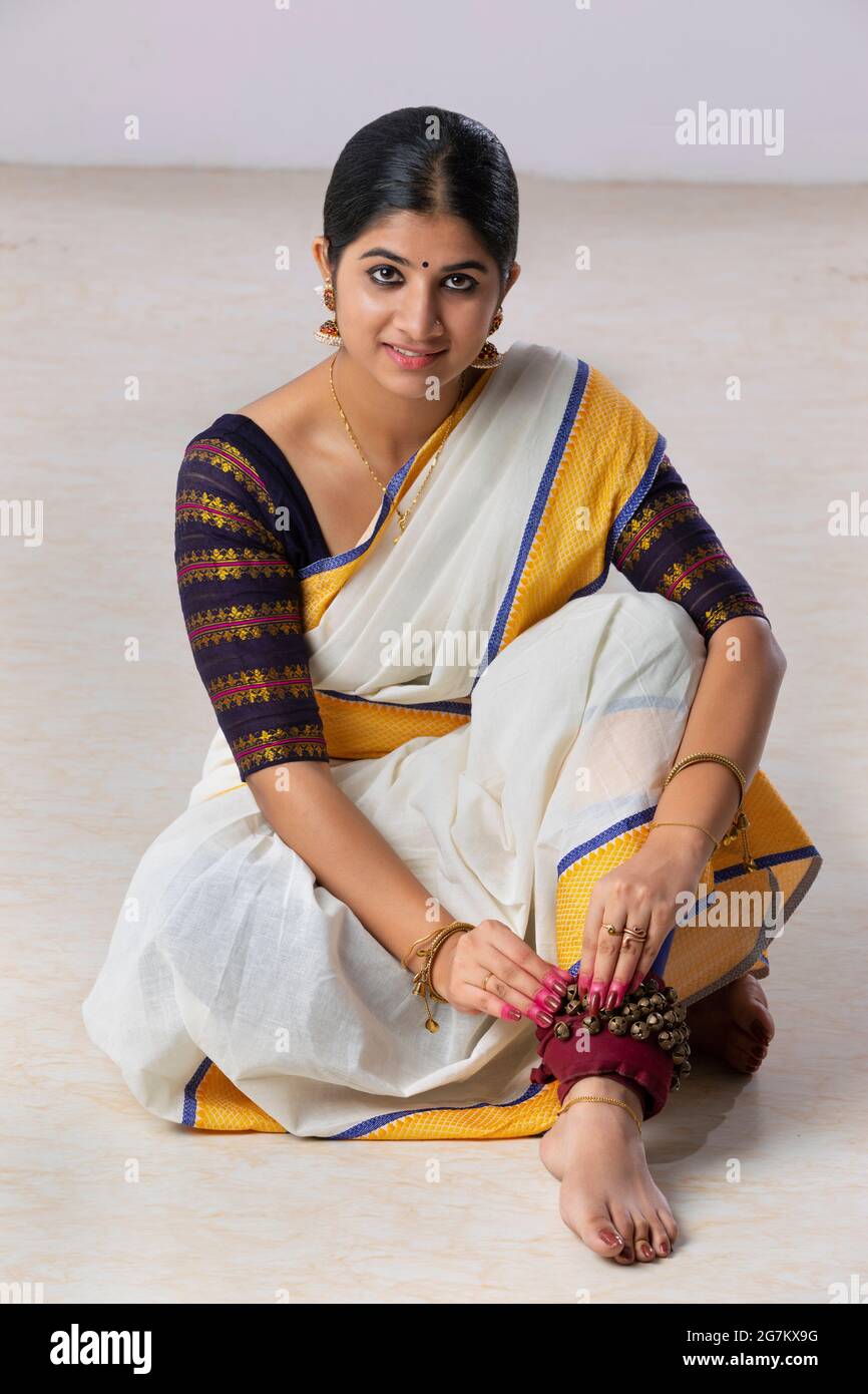 Classical dancer in a saree tying ghungroo on her feet Stock Photo - Alamy