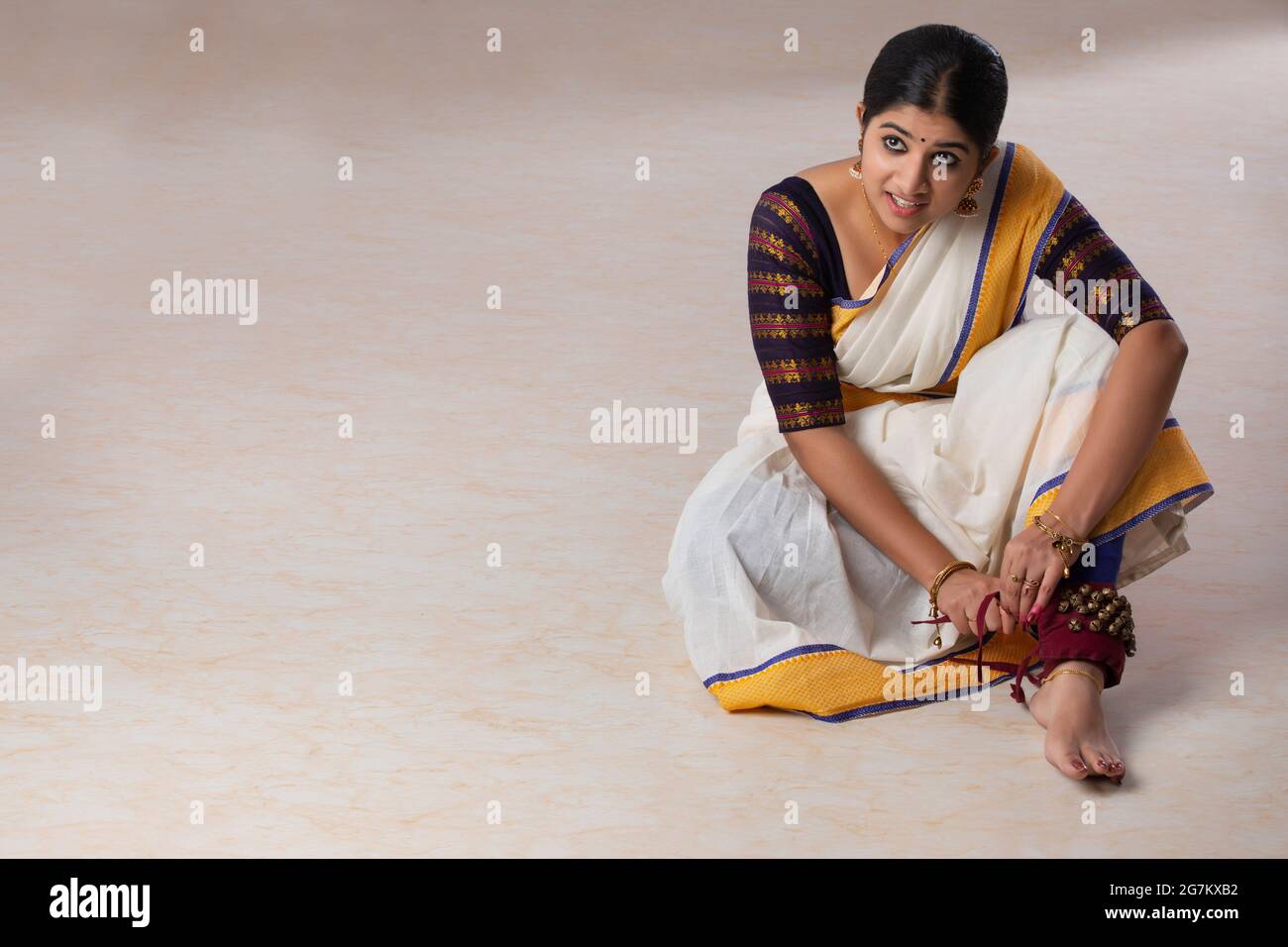Classical dancer in a saree tying ghungroo on her feet Stock Photo - Alamy