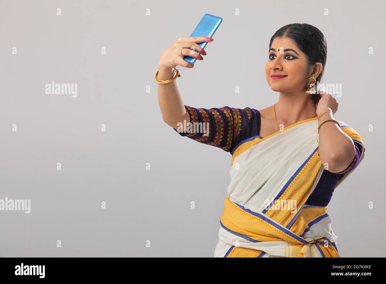 Woman smiling while clicking a selfie on her phone Stock Photo - Alamy