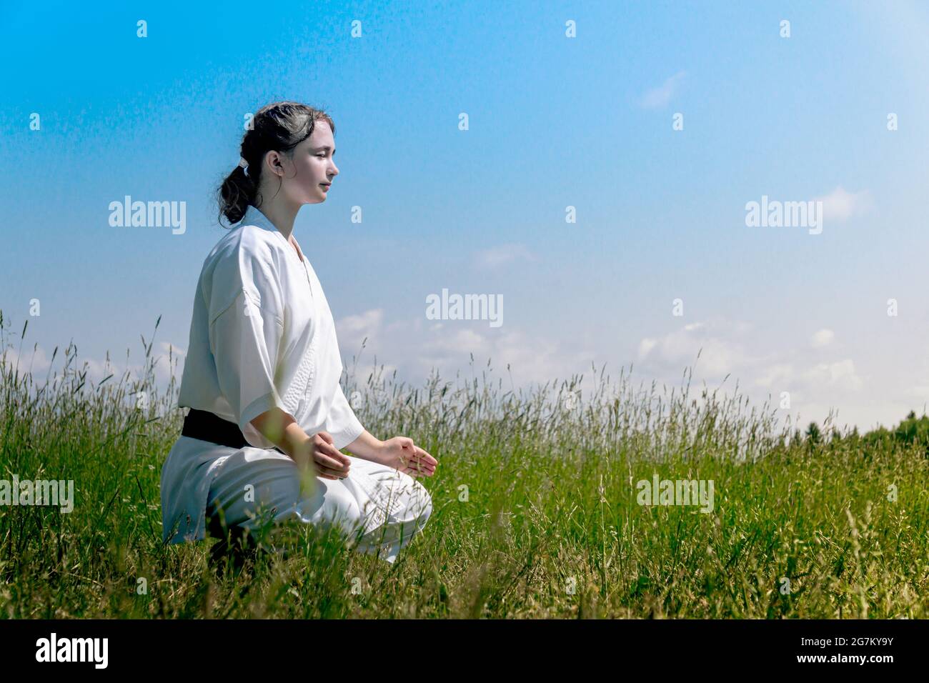 teenage girl karateka before starting workout outdoor enters the mokuso ...