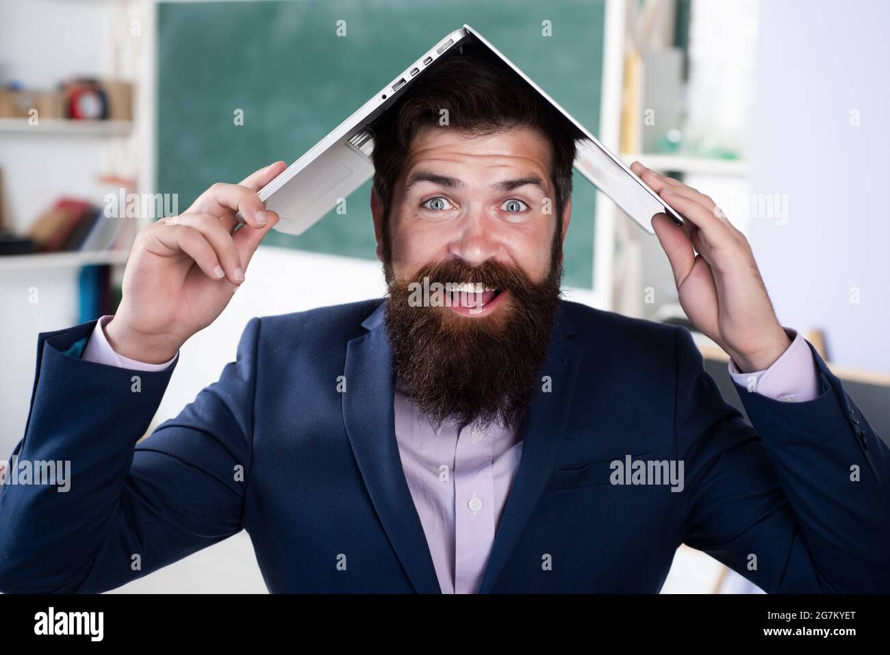 Funny teacher with laptop notebook in classroom at school. Excited ...