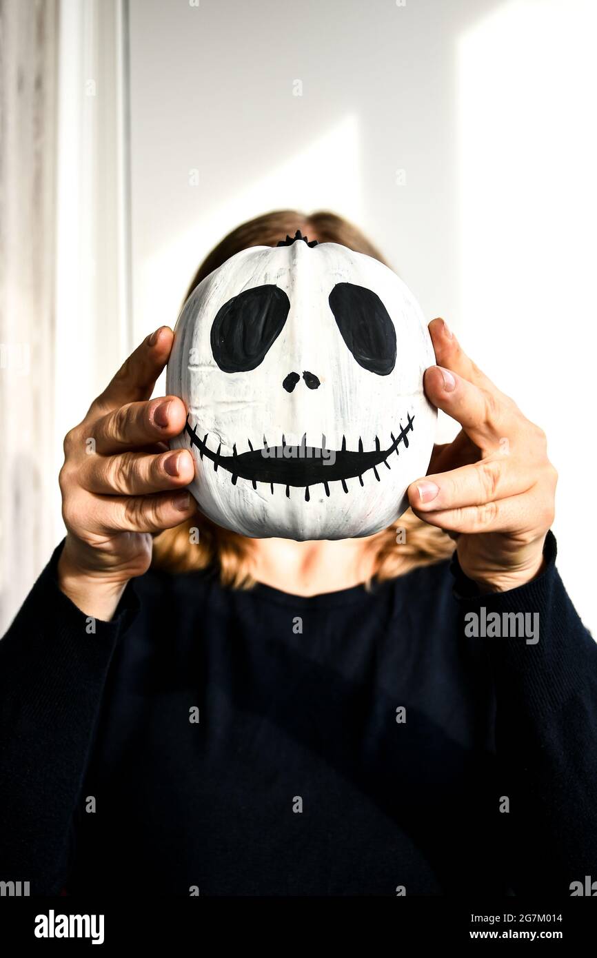 Woman holding Funny pumpkin face in front of her face. Halloween ...
