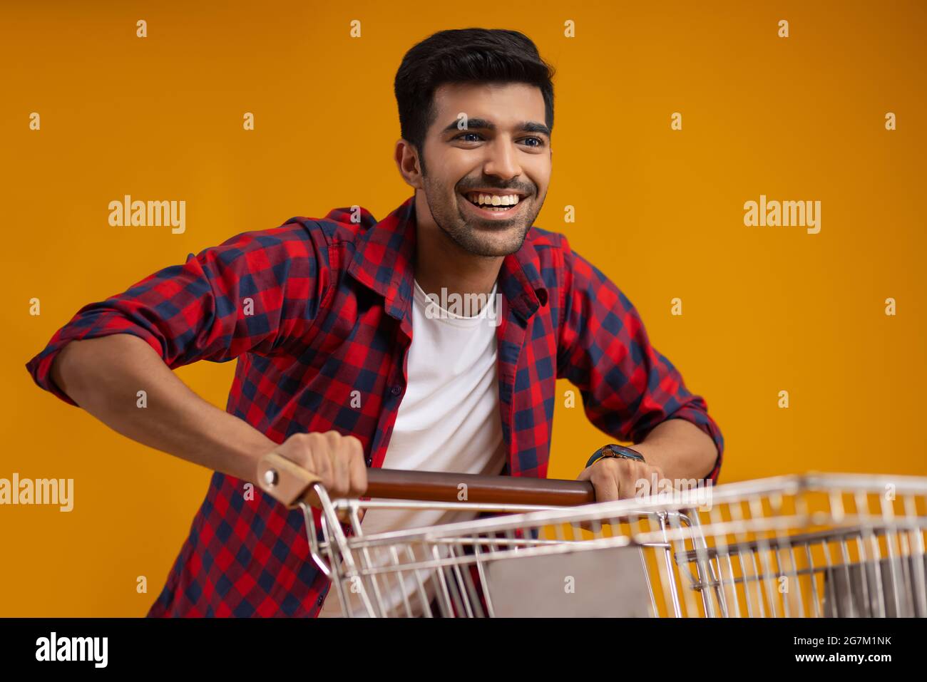 A young boy looking elsewhere holding a trolley Stock Photo - Alamy