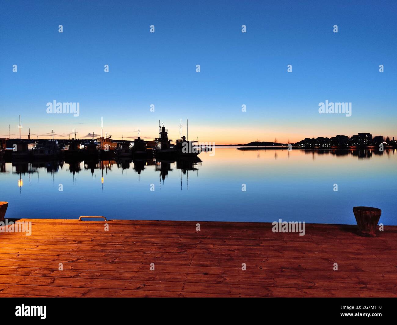 Scenic sunset at a port under a clear blue sky Stock Photo - Alamy