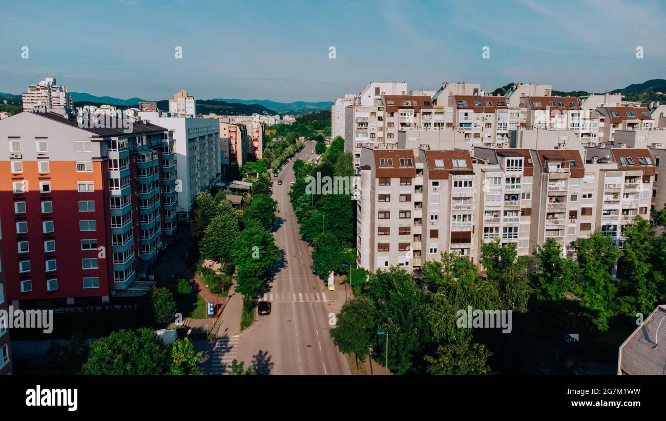 Aerial shot of brown and white buildings surrounded by trees in Tuzla ...