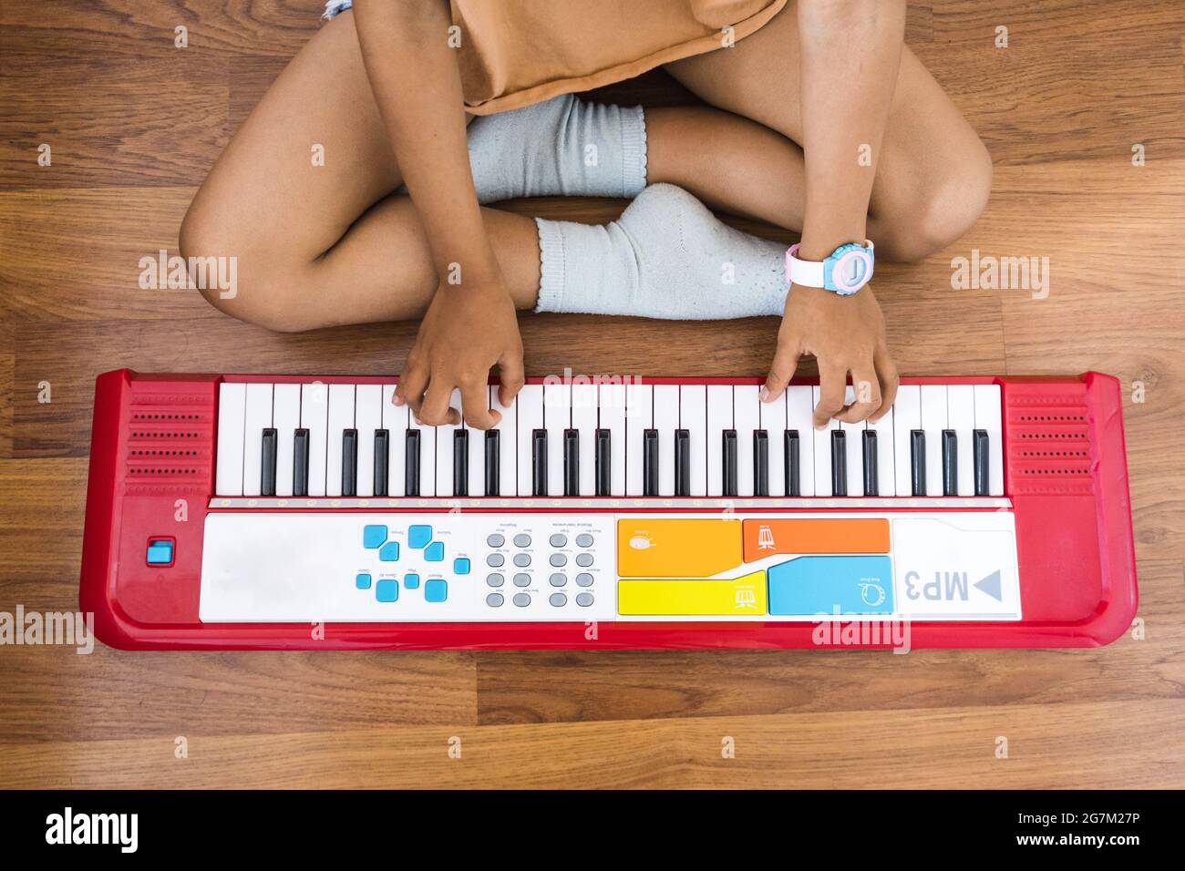 Female playing piano while sitting on the floor Stock Photo - Alamy