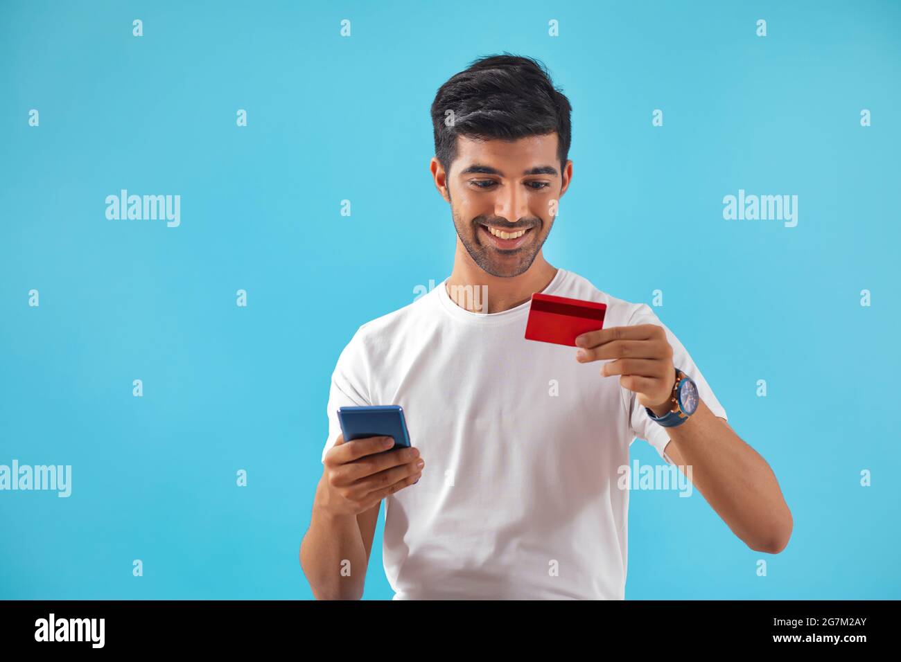 A young boy placing an order with his credit card and mobile phone ...