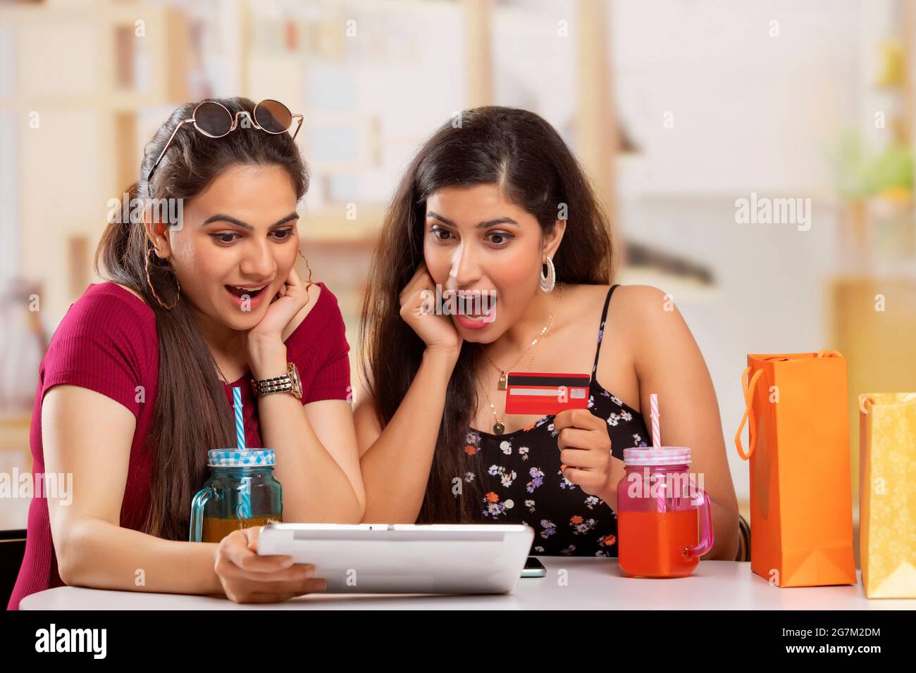 Two Girls Surprised With The Deals And Variety In Online Shopping Stock