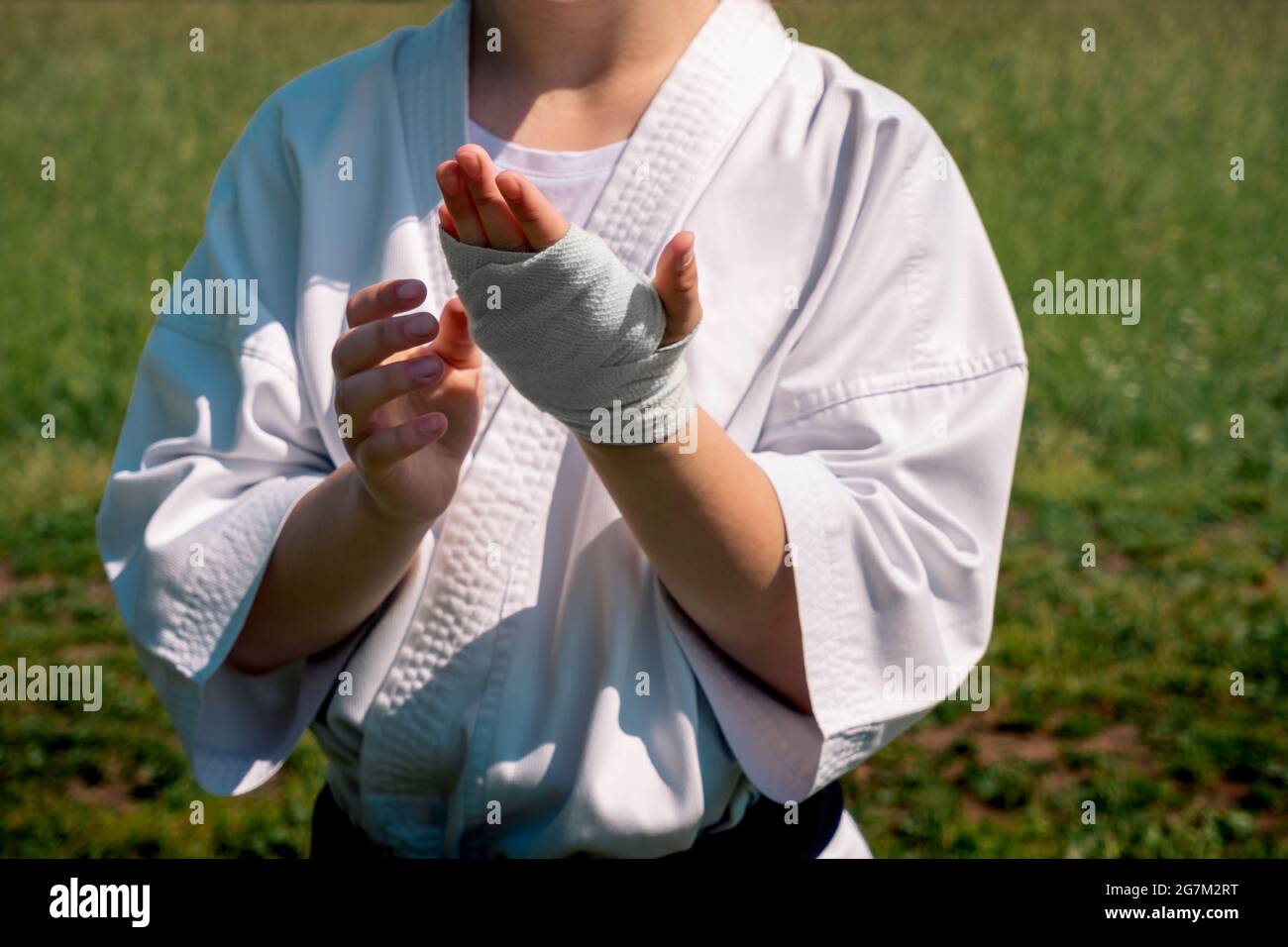 teenage girl in a kimono wrapping a wrist wrap around her hand before ...