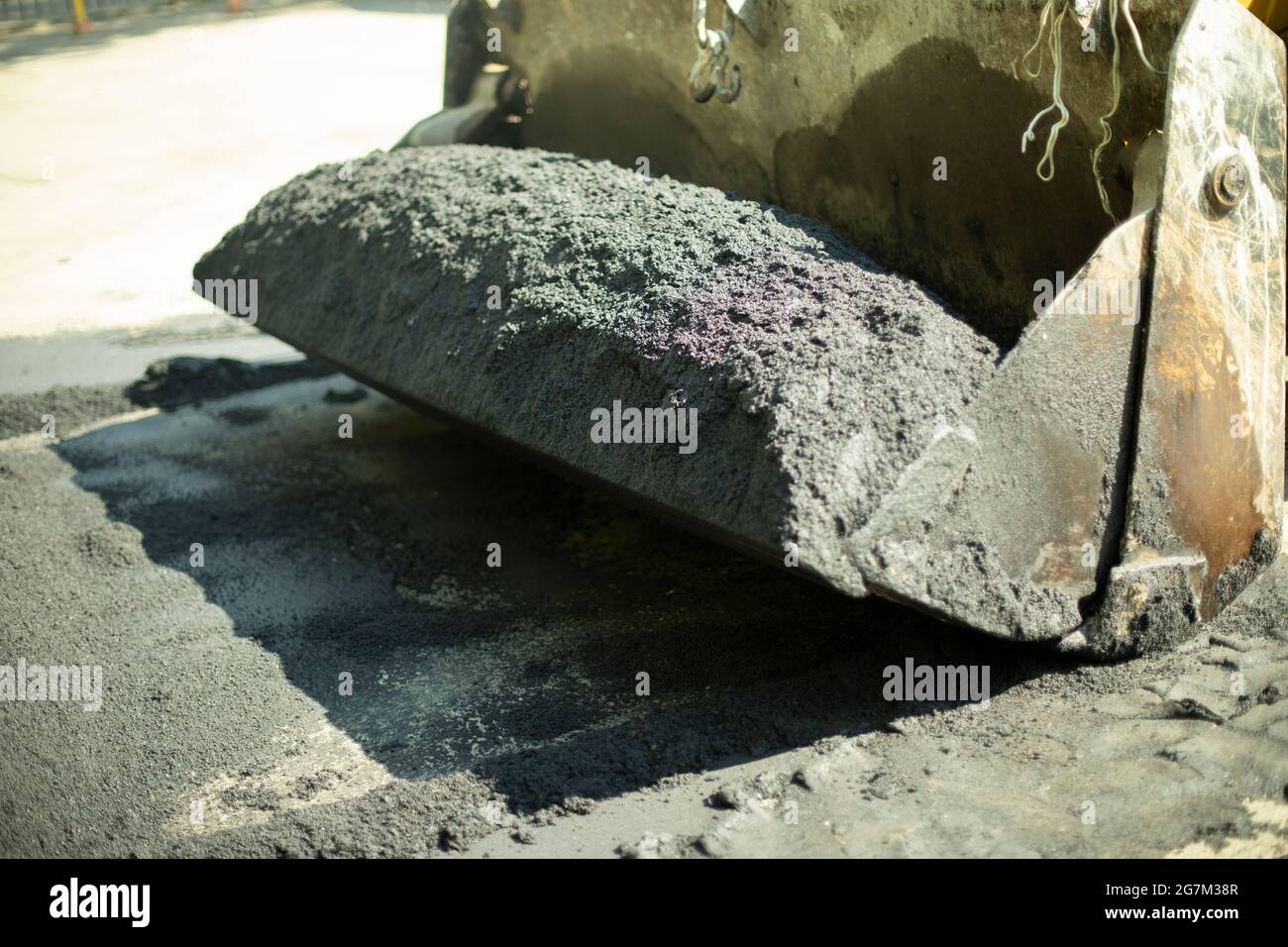 Excavator bucket with asphalt. Laying asphalt on the road. A bucket ...