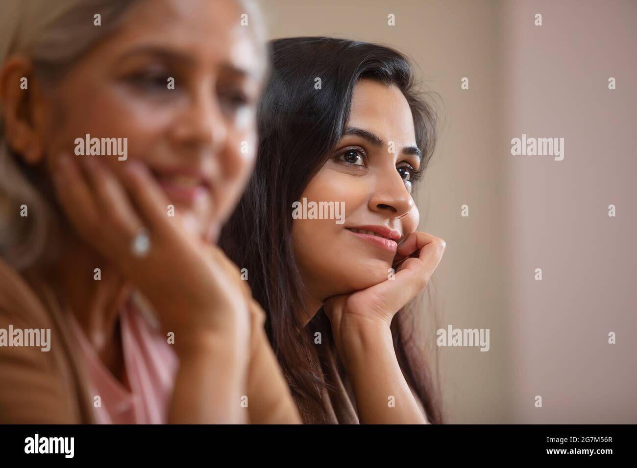 A YOUNG WOMAN SITTING AND THINKING WITH MOTHER SITTING AHEAD Stock ...