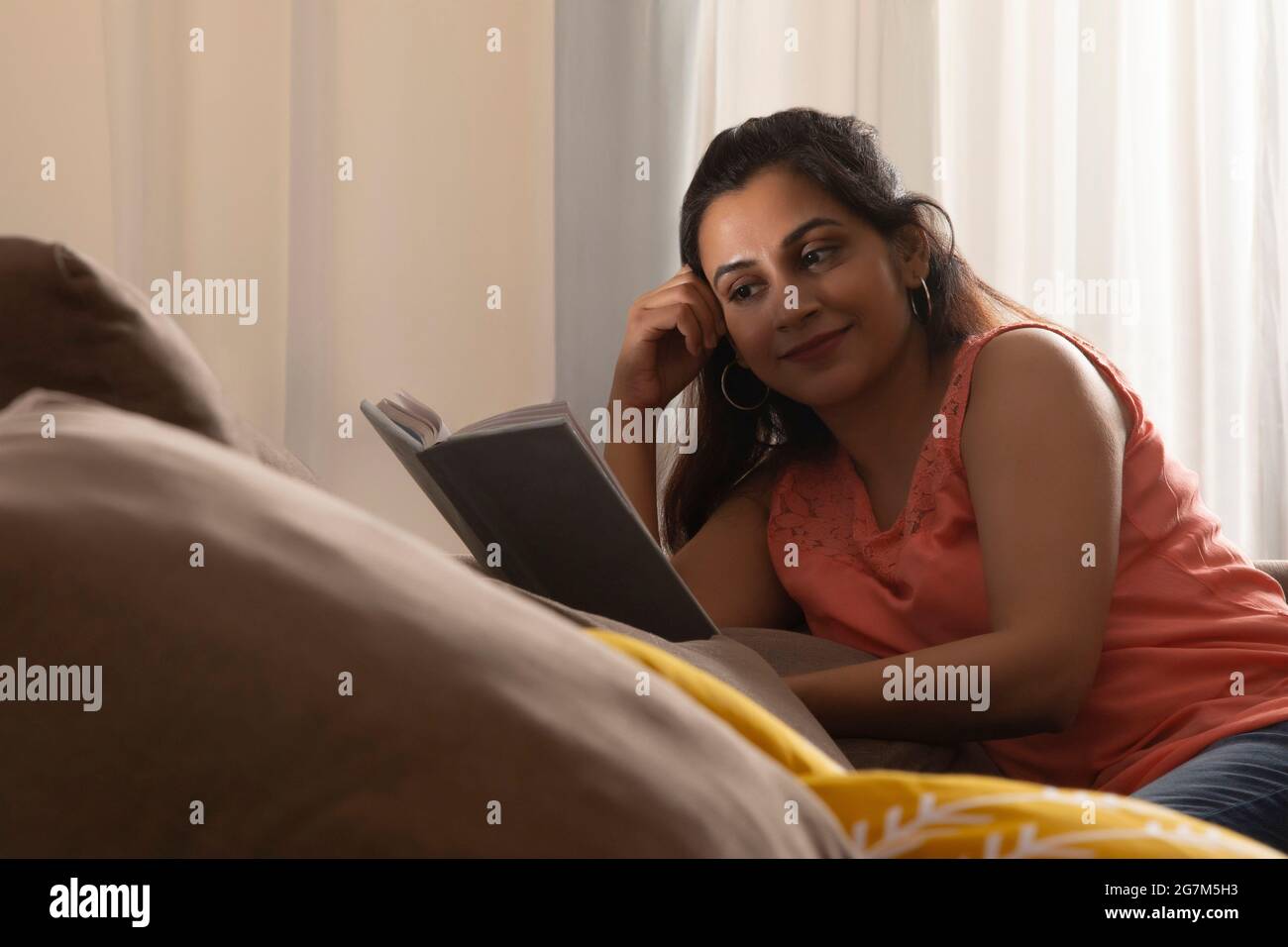 A YOUNG WOMAN HAPPILY READING BOOK Stock Photo - Alamy