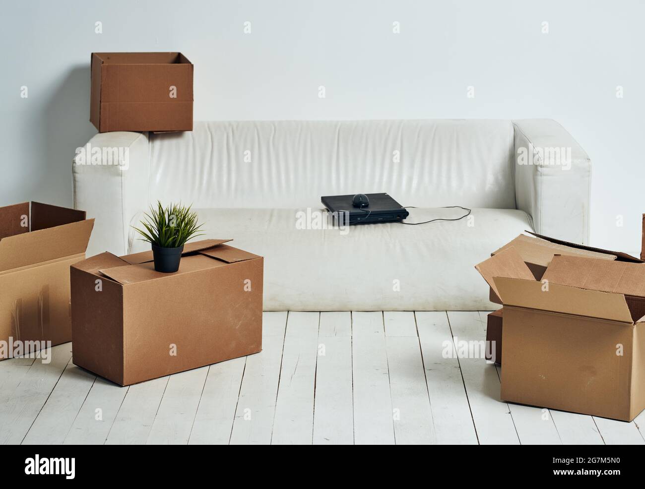 white sofa laptop boxes with things new place of work Stock Photo - Alamy