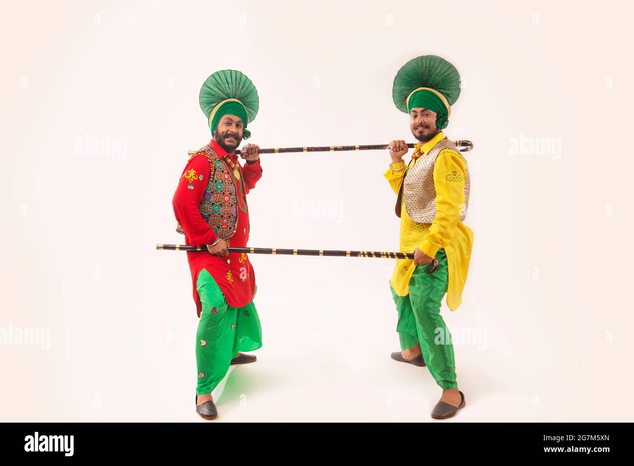 Two Bhangra dancers performing a dance step together using Khunda Stock ...