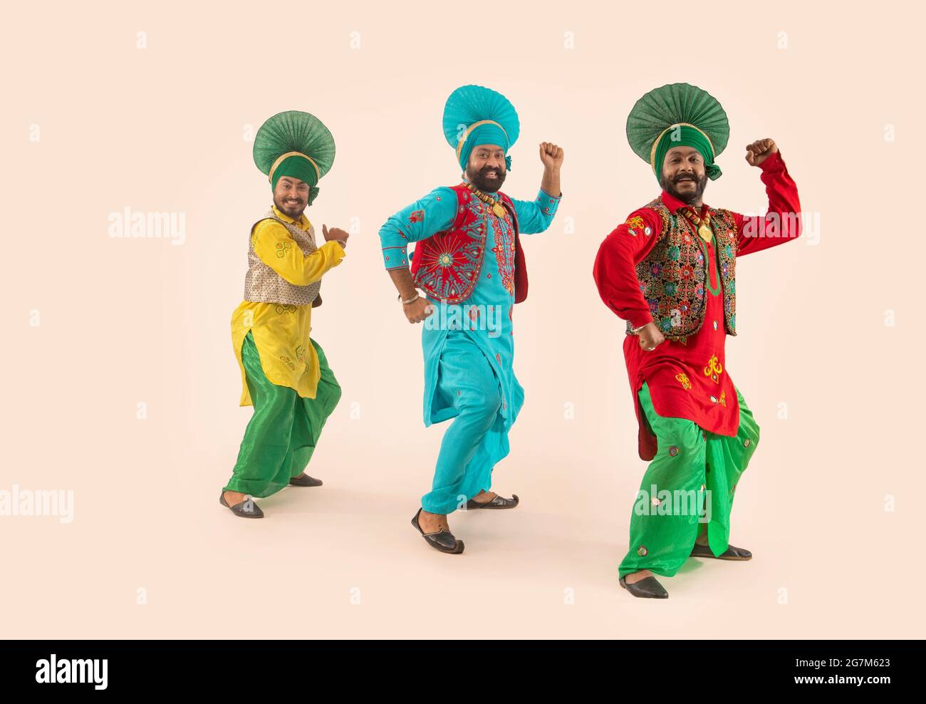 Three Bhangra dancers performing a dance step with hand gestures Stock ...