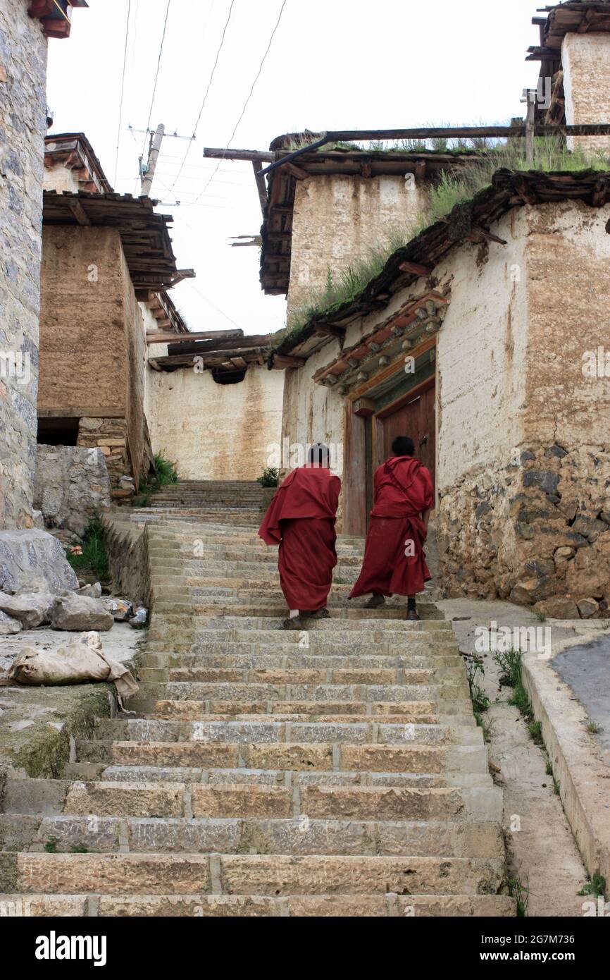 Monks climbing up a stone staircase in the streets in Shangri-La, China ...