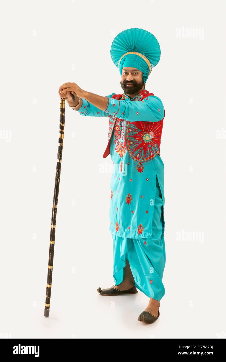 A Bhangra dancer holding a Khunda in his hand Stock Photo - Alamy