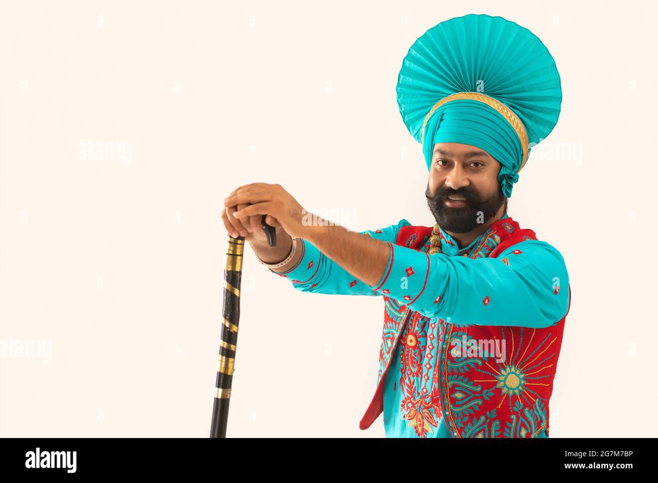 A Bhangra dancer holding a Khunda in his hand Stock Photo - Alamy