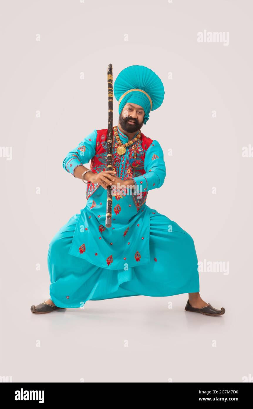 A Bhangra dancer holding a Khunda in his hand Stock Photo - Alamy