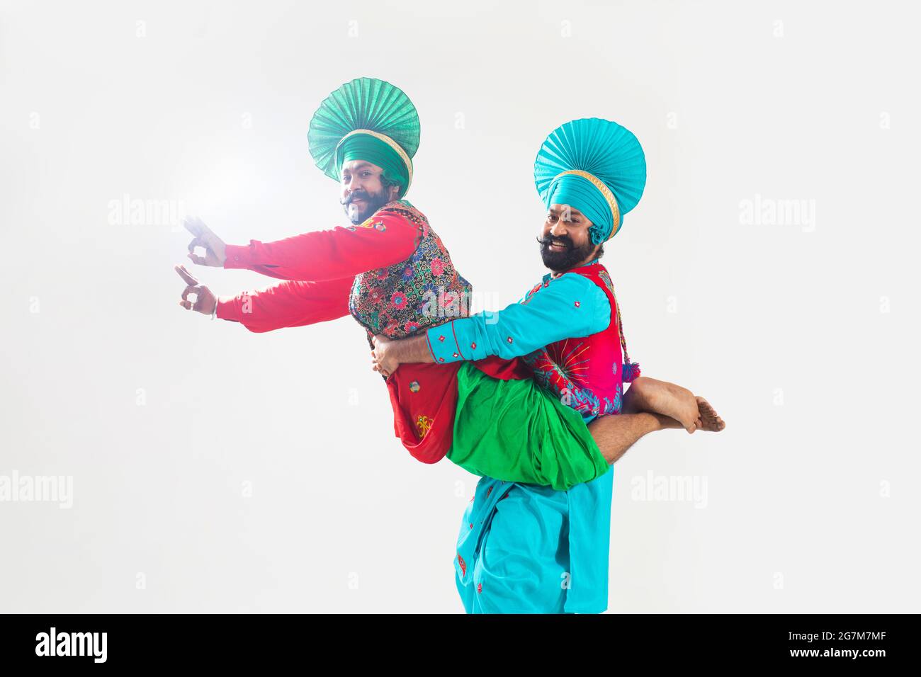 Two Bhangra dancers striking a classic step of their dance form Stock ...