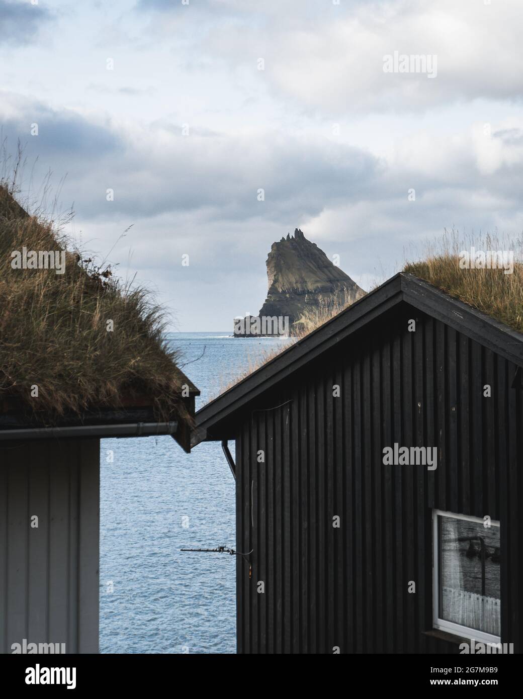 Vertical photo of a rock erupting through the water in Bour, Faroe ...