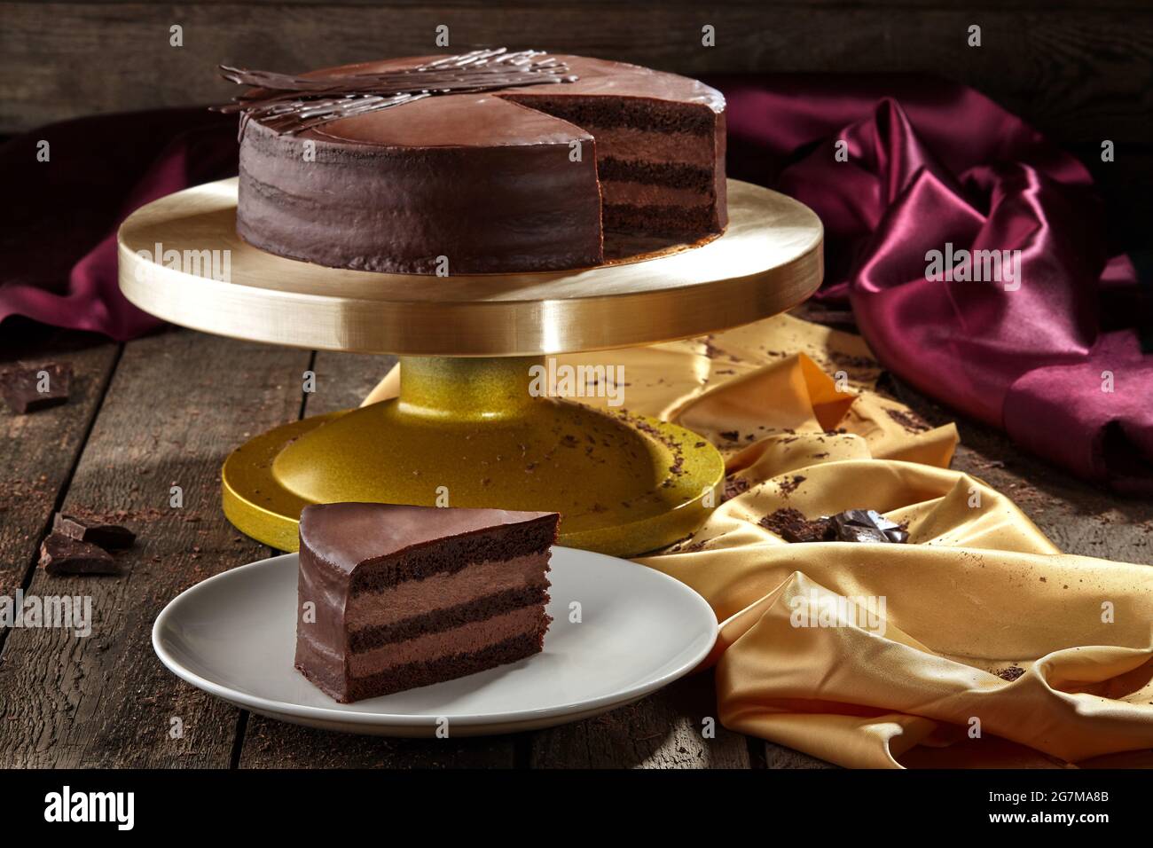 Sliced chocolate sponge cake with buttercream topped with ganache Stock ...