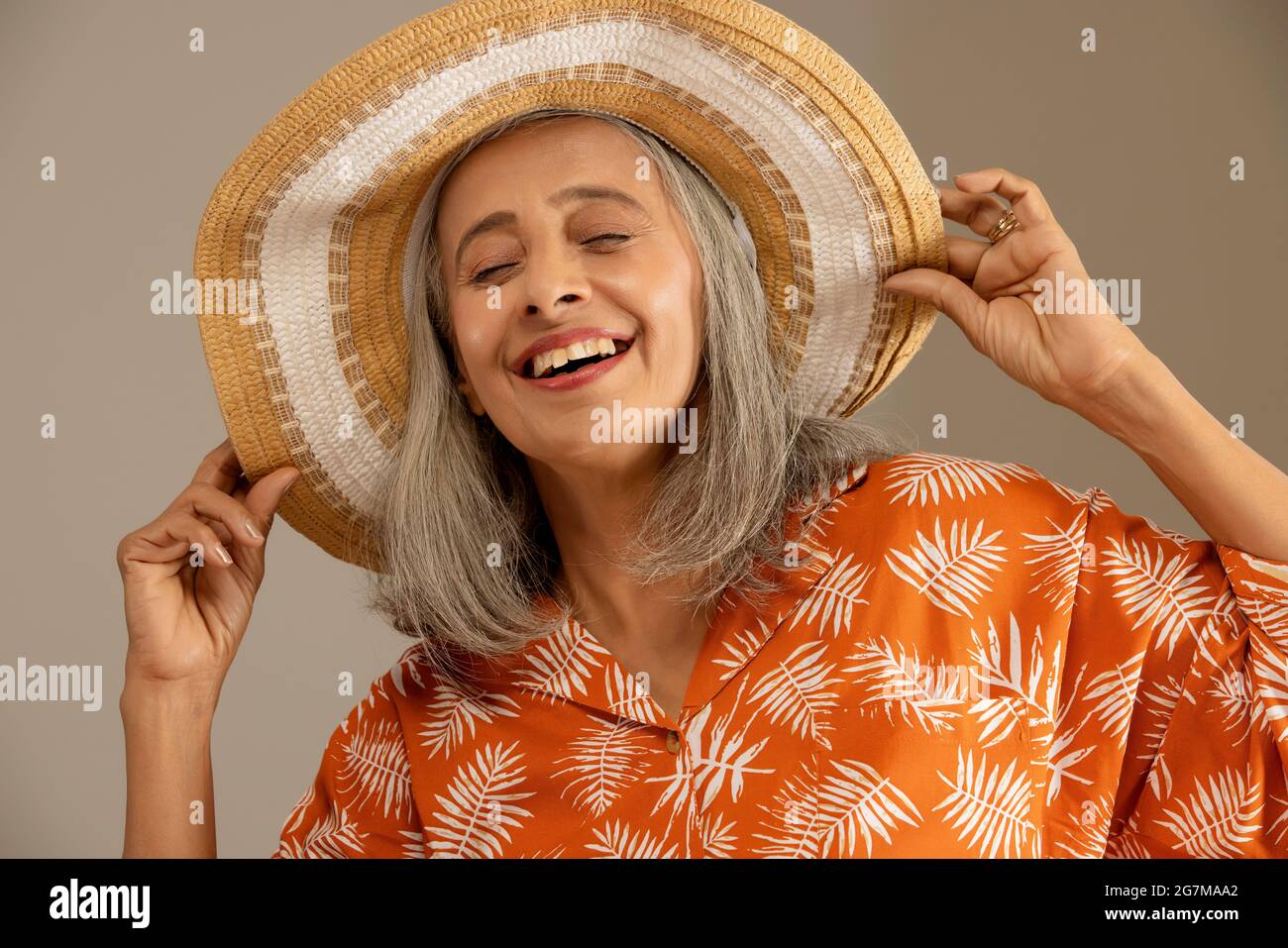 A happy old woman flaunting her hat Stock Photo - Alamy
