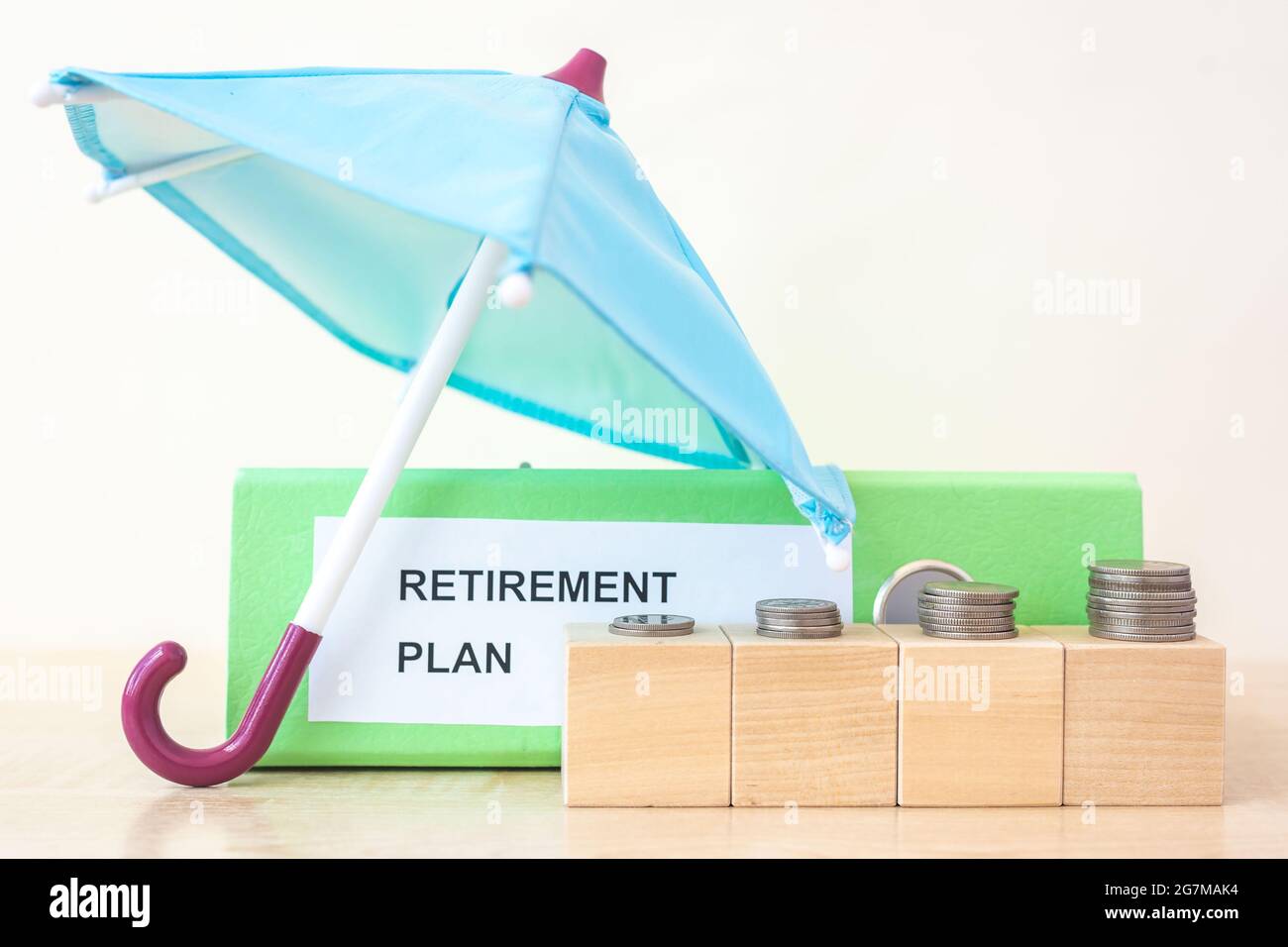 Coins on blocks folder with Retirement Plan and umbrella Stock Photo ...