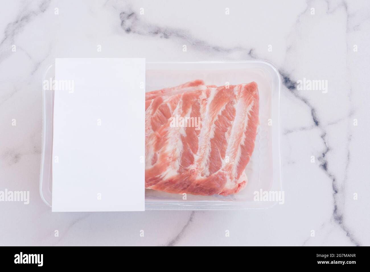 Raw pork ribs in vacuum packaging on marble background, logo mockup for ...