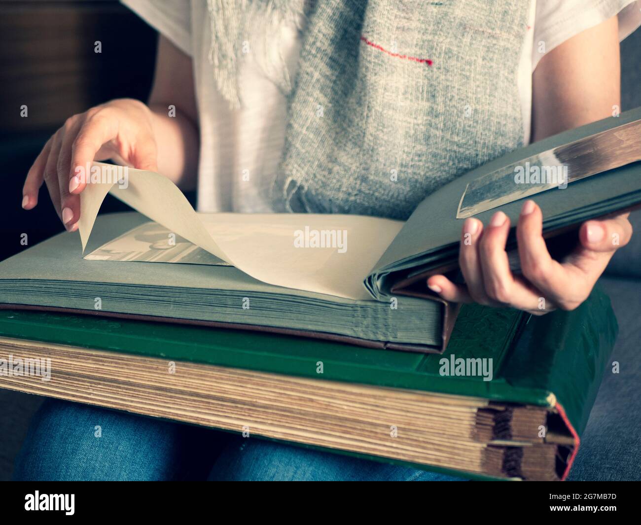 Woman is looking at black and white photos on the pages of her family ...