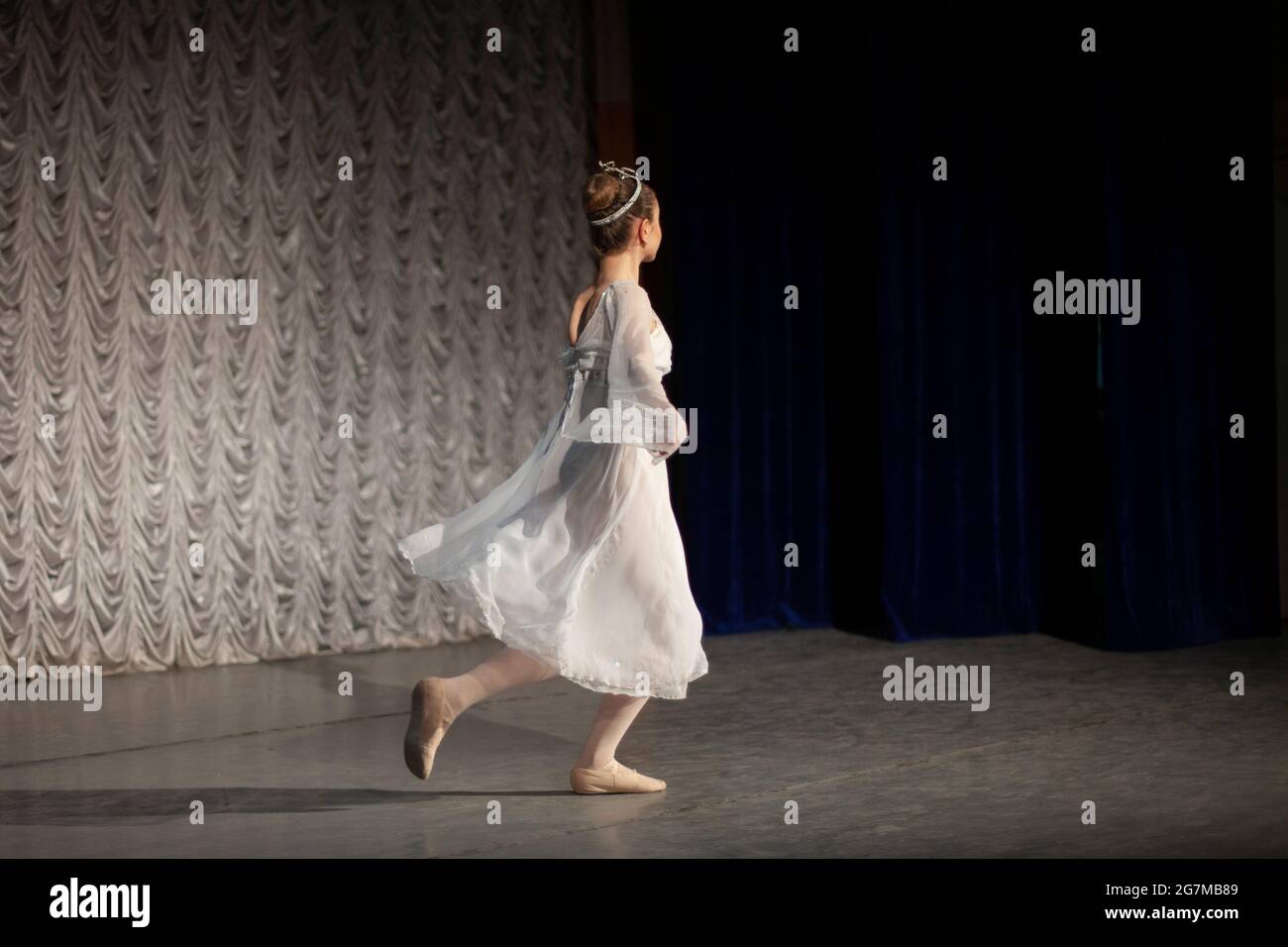 The girl dances in a classic dance dress. The performance of a young ...