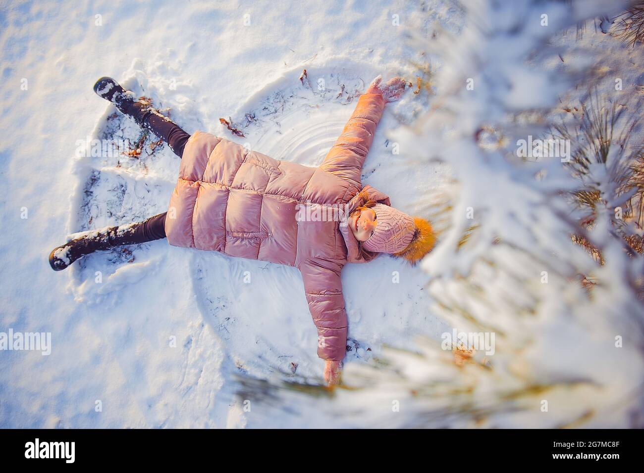 Cute little kid girl making snow angel outdoors. Children outdoor ...