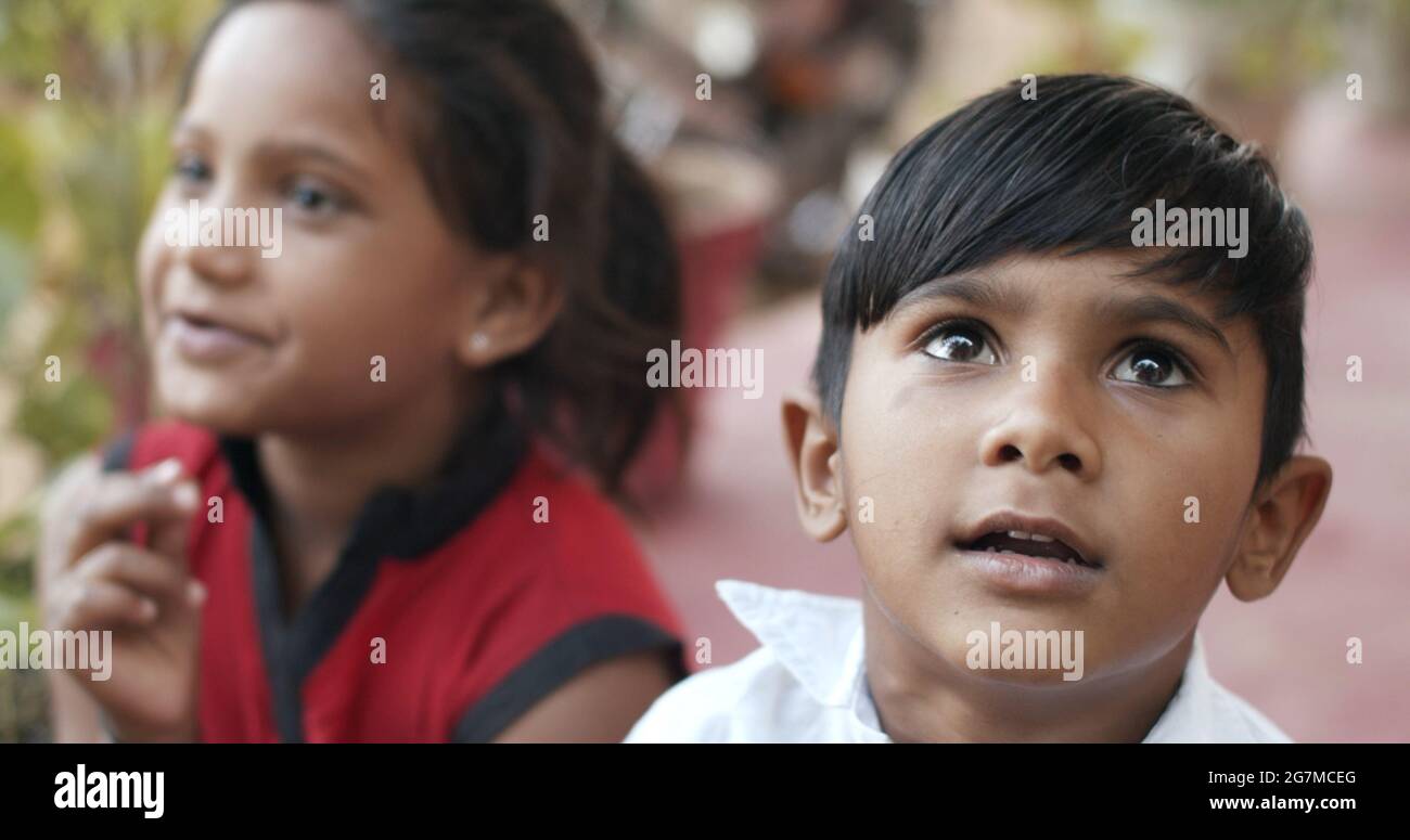 Two indian kids looking up surprised and smiling Stock Photo - Alamy