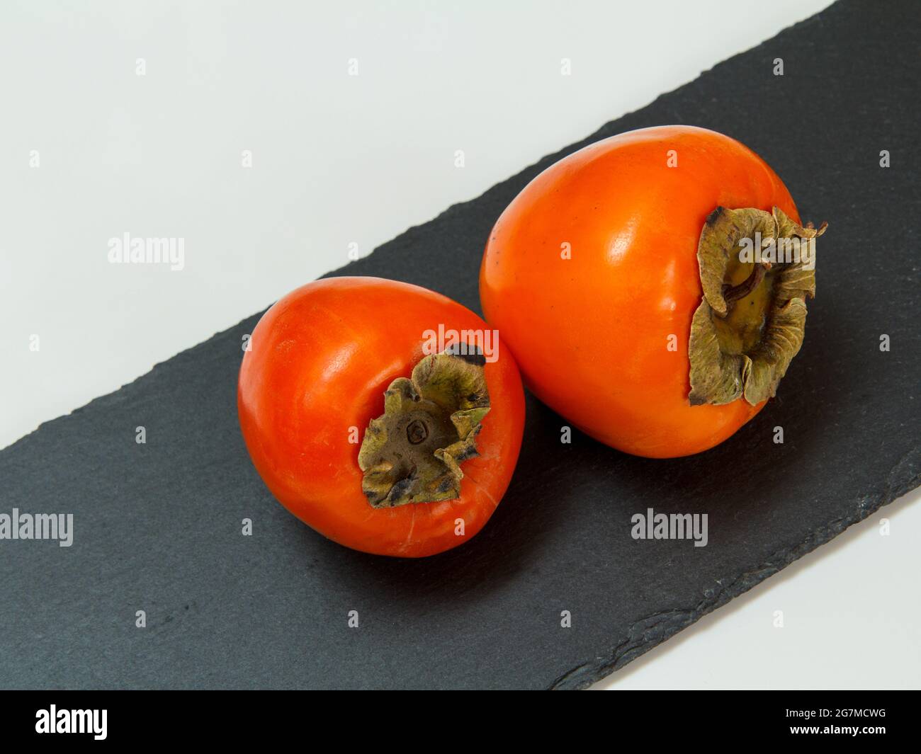 Ripe fresh persimmon fruits on stone cutting board Stock Photo - Alamy
