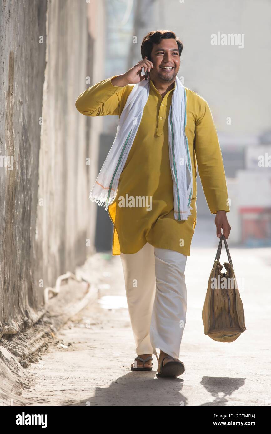 A RURAL MAN HAPPILY WALKING WHILE TALKING OVER PHONE Stock Photo - Alamy