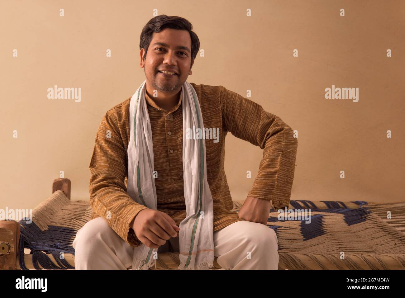 A HAPPY VILLAGER SITTING ON A COT AND SMILING AT CAMERA Stock Photo - Alamy