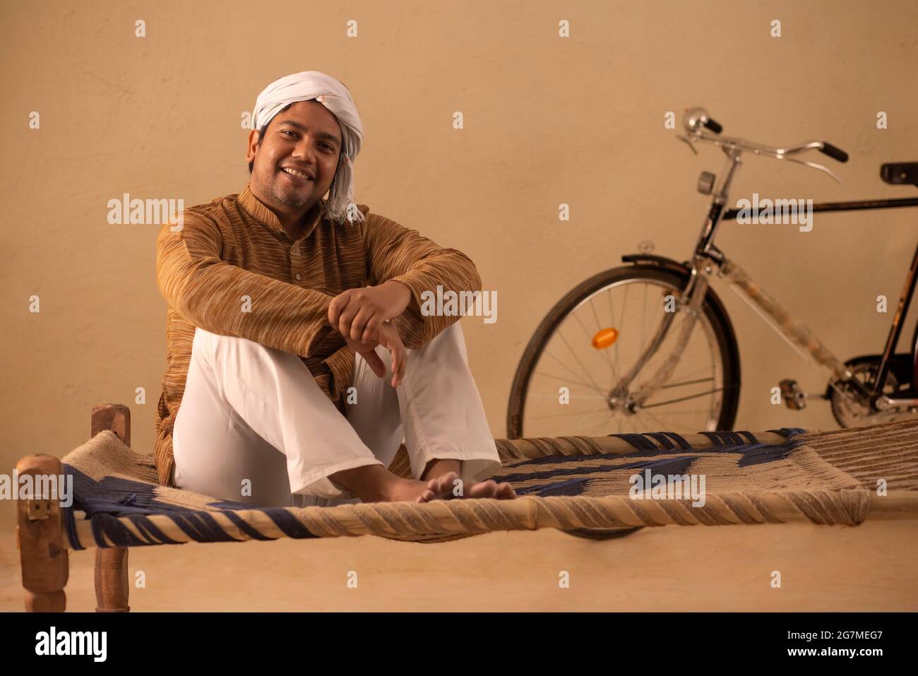 A RURAL MAN COMFORTABLY SITTING ON COT AND LOOKING AT CAMERA Stock ...