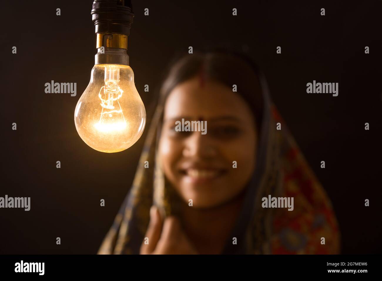 AN IMAGE OF A RURAL WOMAN IN BACKGROUND OF AN ELECTRIC BULB Stock Photo ...