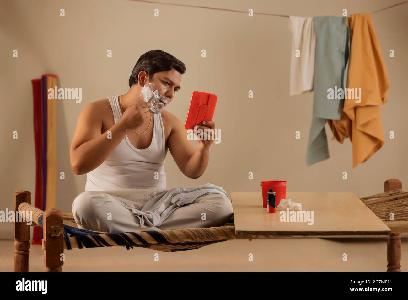 A RURAL MAN SHAVING WHILE SITTING ON A TRADITIONAL COT Stock Photo - Alamy